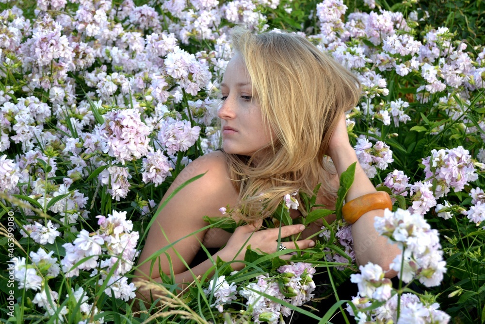 Girl sitting in a field of flowers Stock Photo | Adobe Stock
