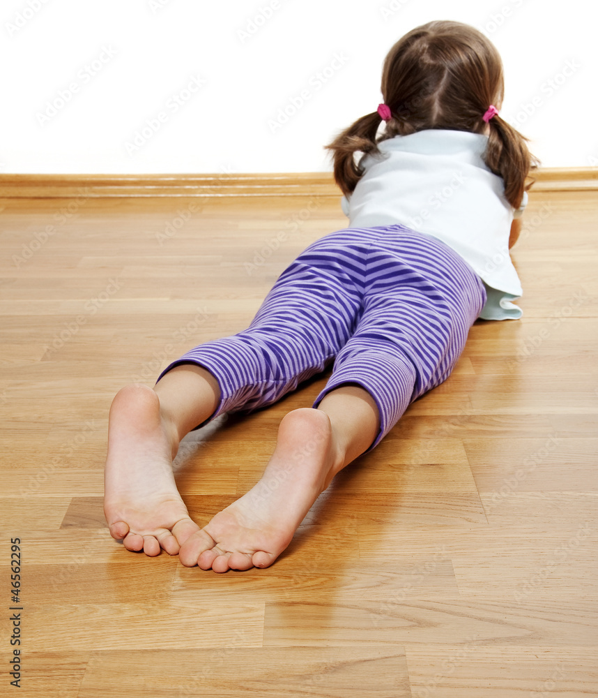 barefoot - a little girl resting on a wooden floor Stock Photo | Adobe Stock