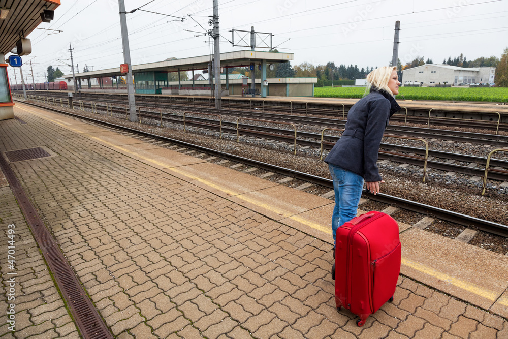 Frau wartet auf Bahnhof auf ihren Zug Stock-Foto | Adobe Stock