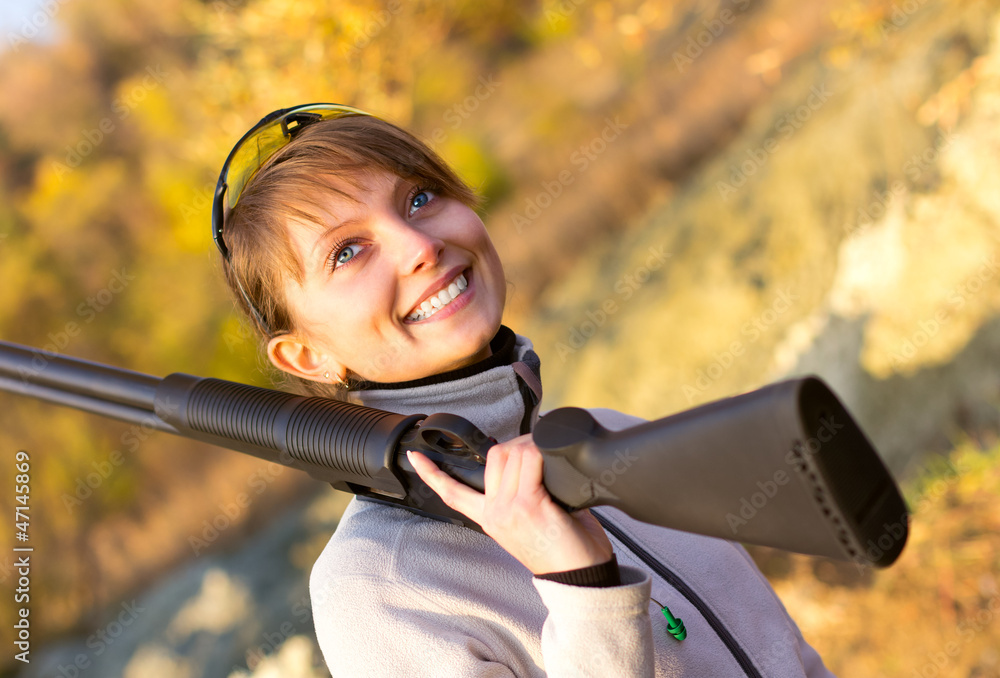Young beautiful girl with a shotgun Stock Photo | Adobe Stock