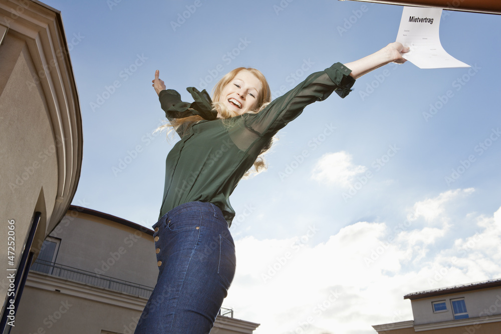 Freudensprung einer jungen Frau mit Mietvertrag Stock Photo | Adobe Stock