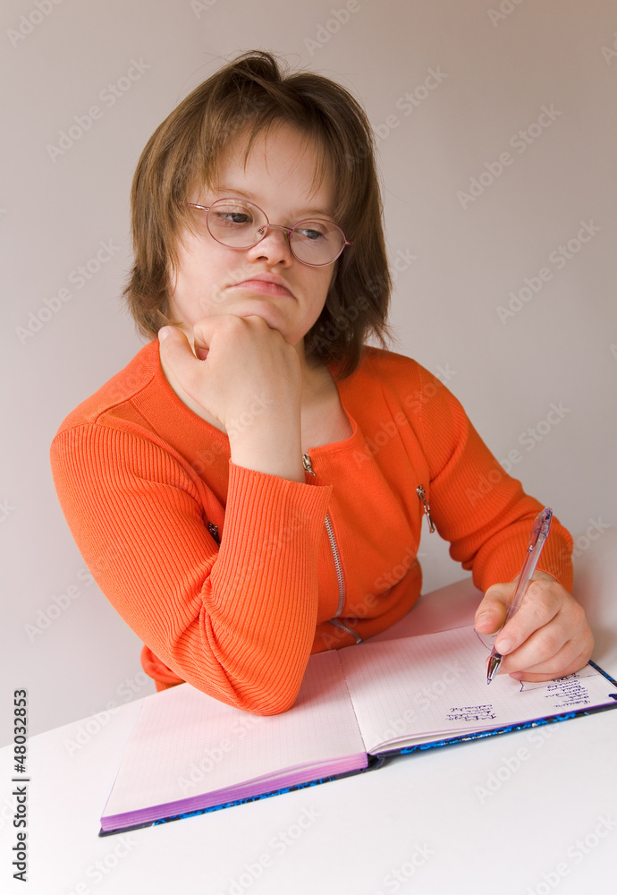 A girl with down syndrome writing. Stock Photo | Adobe Stock