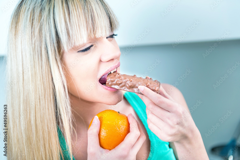beautiful woman biting a bar of chocolate Stock Photo | Adobe Stock