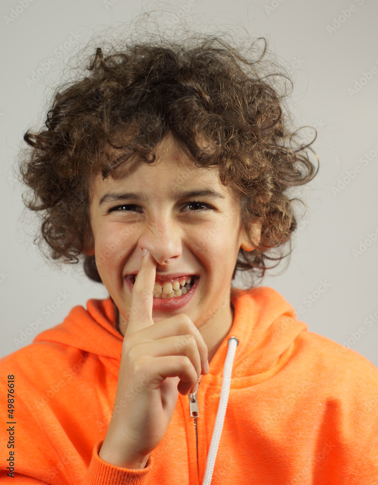 A young boy is picking his nose with a cheeky smile Stock Photo | Adobe ...