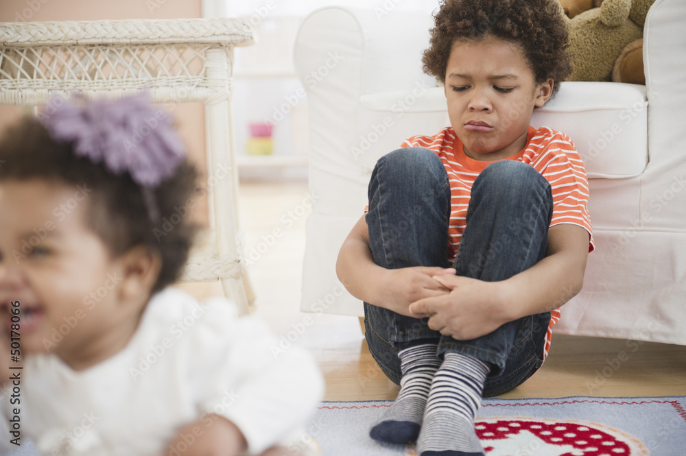 Sad Black boy sitting in living room Stock Photo | Adobe Stock