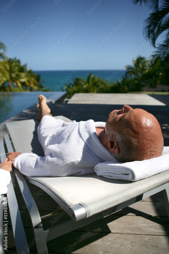 Old man laying on poolside sun lounger Stock Photo | Adobe Stock