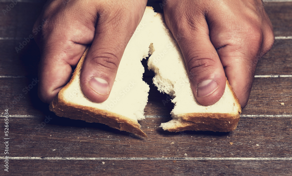 hand breaking apart a bread loaf against Stock Photo | Adobe Stock