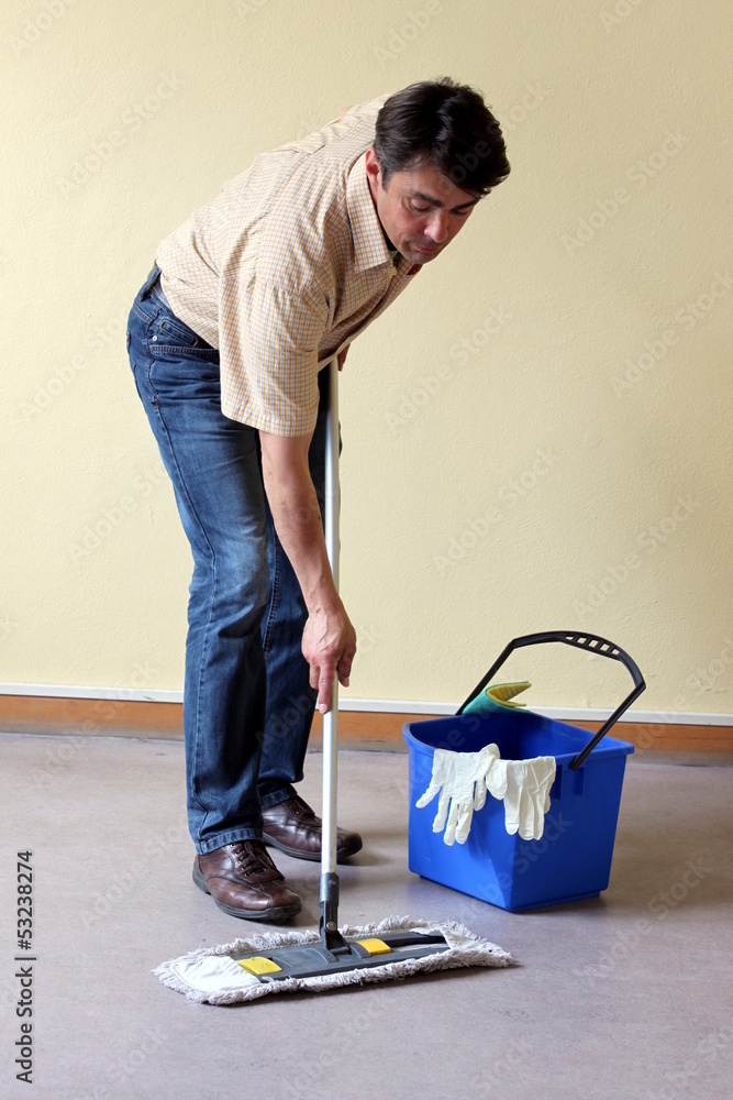 Mann putzt mit Flächenwischer und Putzeimer Stock-Foto | Adobe Stock