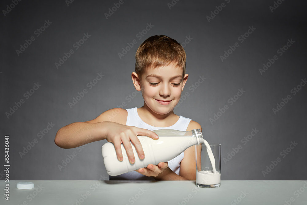Boy pouring milk into glass Stock Photo | Adobe Stock
