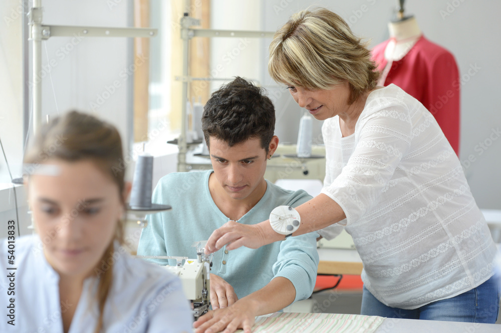 Teacher helping student with sewing machine Stock-Foto | Adobe Stock