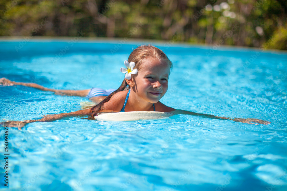Little cute happy girl swims in the swimming pool Stock Photo | Adobe Stock