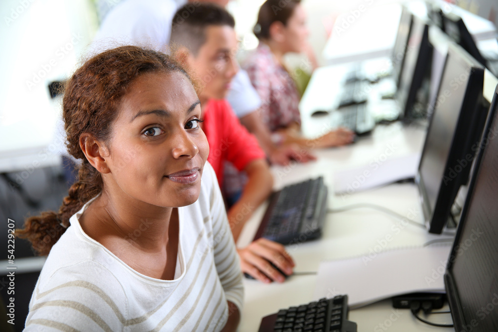 Smiling student girl sitting in computing class Stock Photo | Adobe Stock