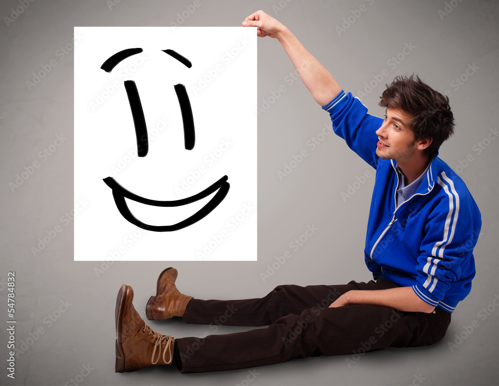 Young boy holding smiley face drawing Stock Photo | Adobe Stock