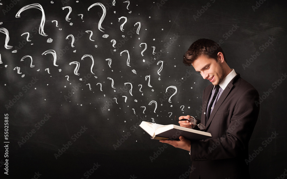 Young man reading a book with question marks coming out from it Stock ...