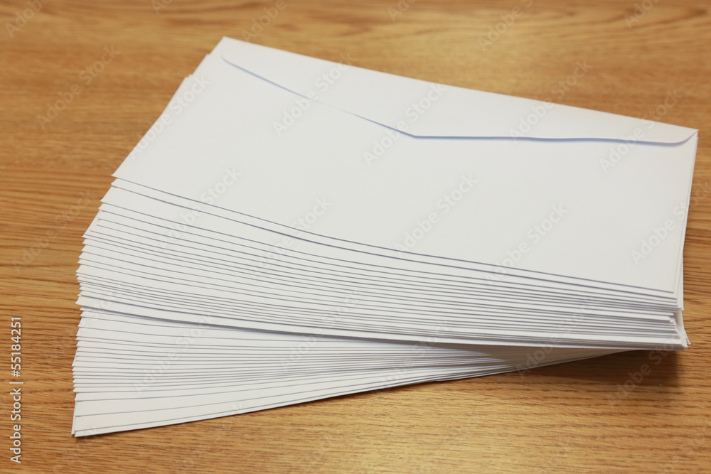stack of white envelopes on a table Stock Photo | Adobe Stock