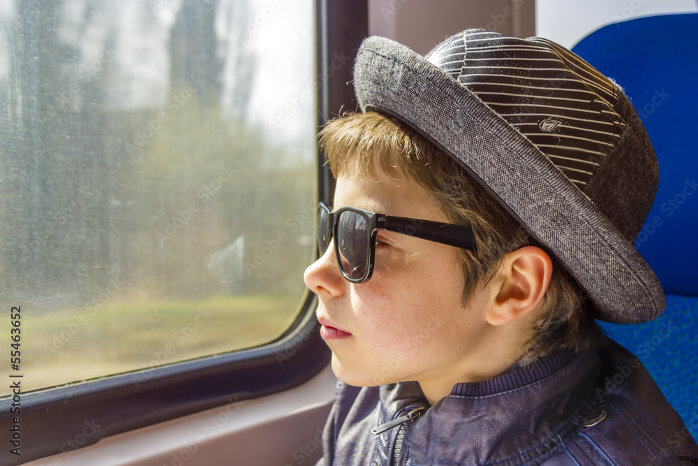 Handsome boy in sunglasses rides on a train Stock Photo | Adobe Stock