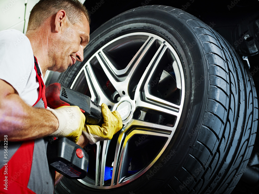 Motor mechanic is fitting a tyre with new alu rim Stock Photo | Adobe Stock
