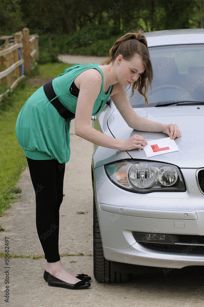 Learner driver putting her L plate on bonnet of car Stock Photo | Adobe ...