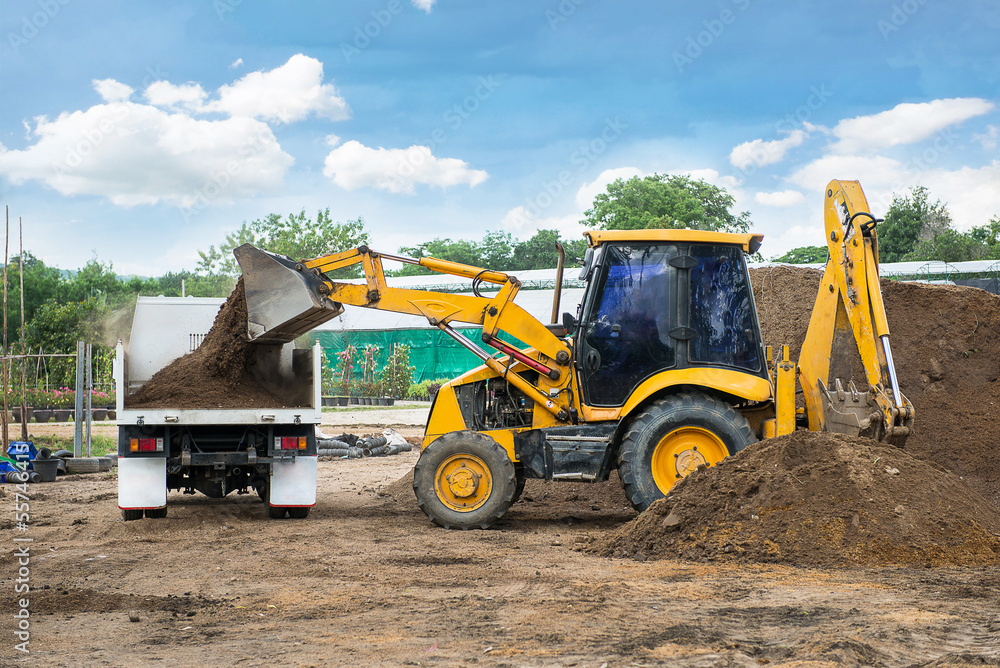 Tractor with front and loader bucket and backhoe with truck Stock Photo ...