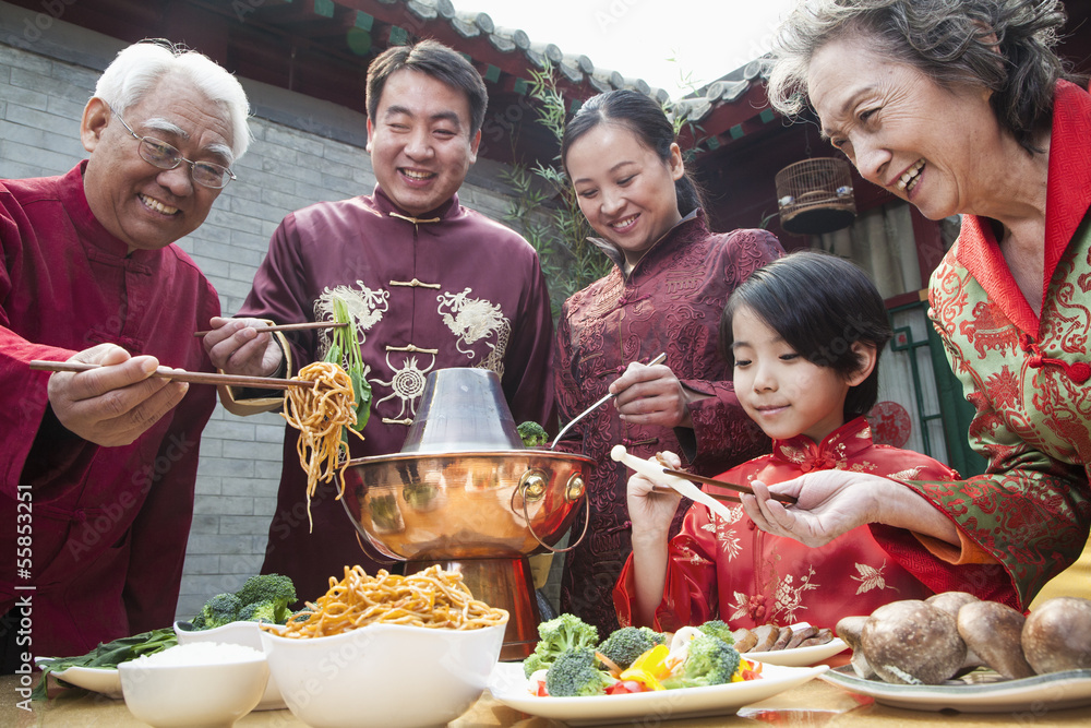 Family enjoying Chinese meal in traditional Chinese clothing Stock ...