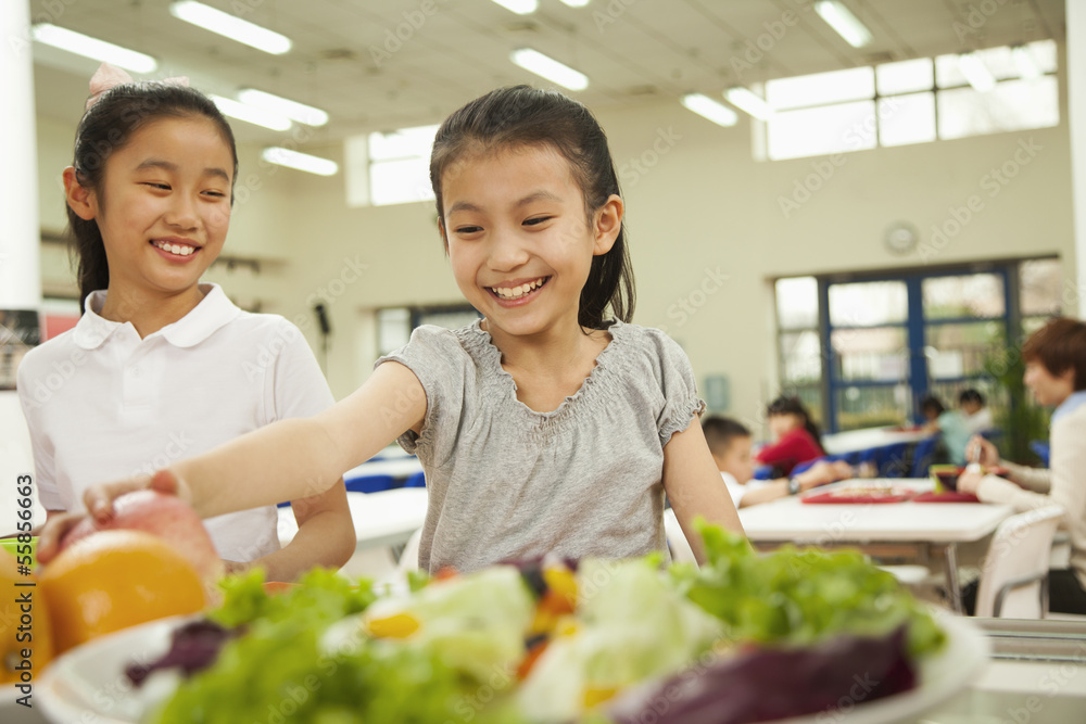 Students reaching for healthy food in school cafeteria Stock Photo ...