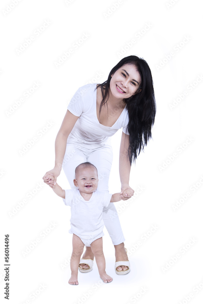 Baby taking first steps with mother help - isolated Stock Photo | Adobe ...