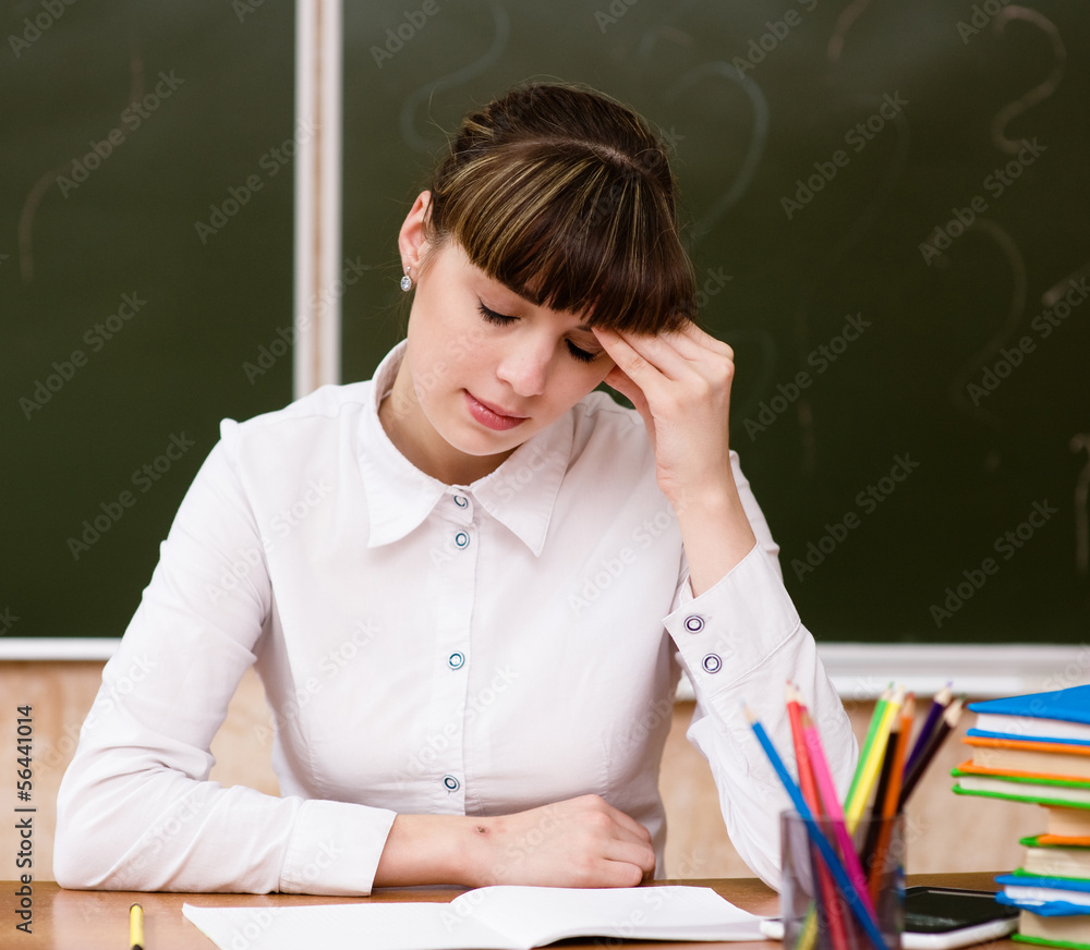 tired teacher in classroom Stock Photo | Adobe Stock