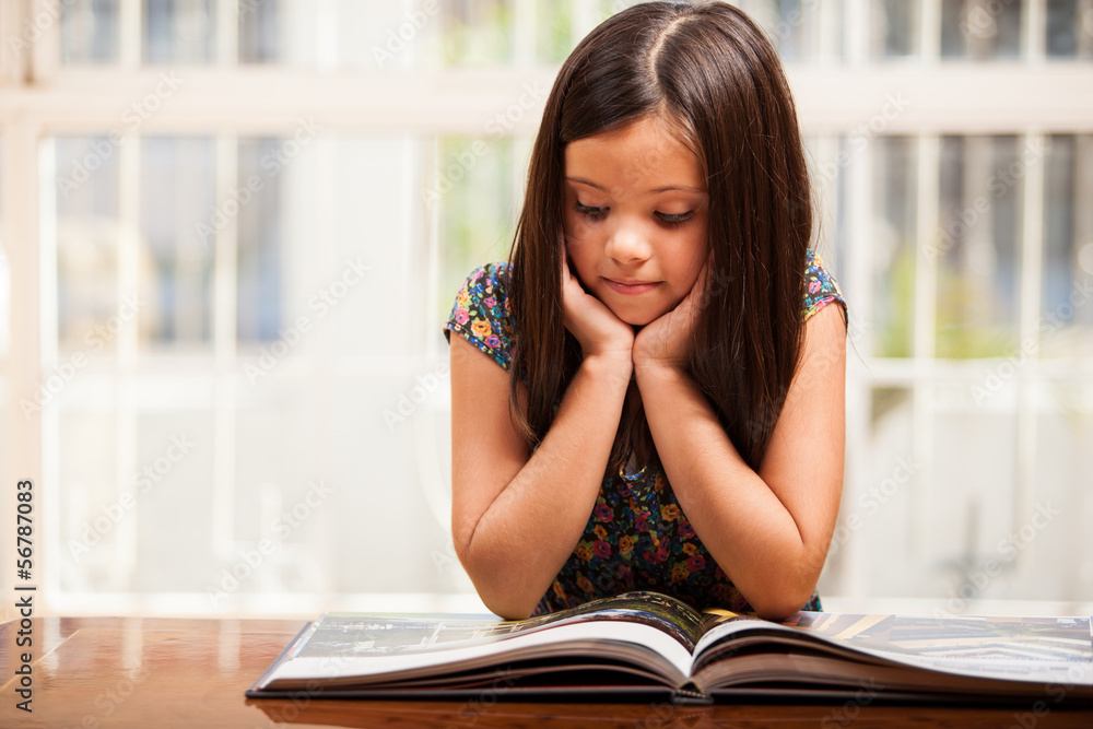 Cute girl reading a storybook Stock Photo | Adobe Stock