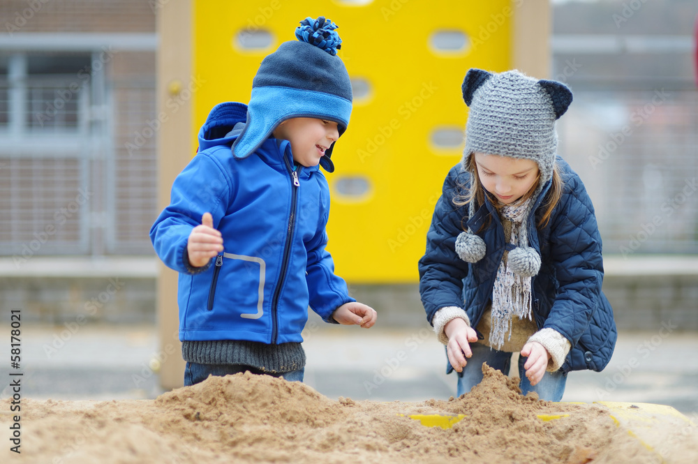 Two kids playing in a sandbox Stock Photo | Adobe Stock