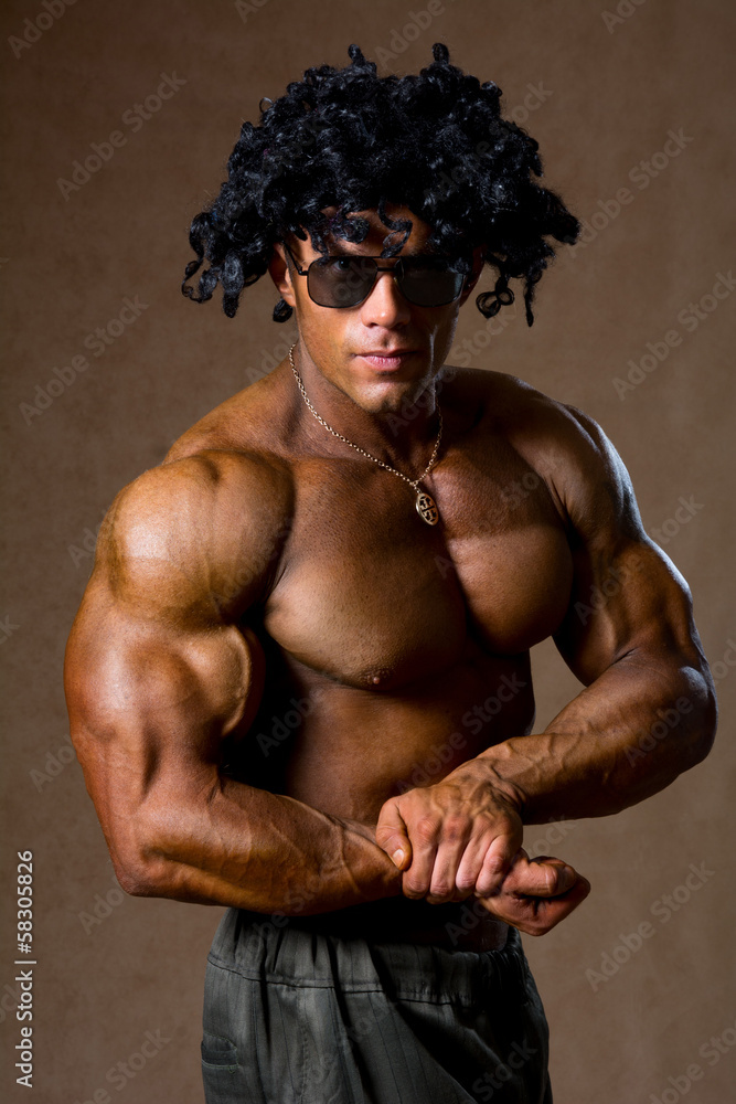 Muscular bodybuilder with curly hair shows his biceps Stock Photo ...