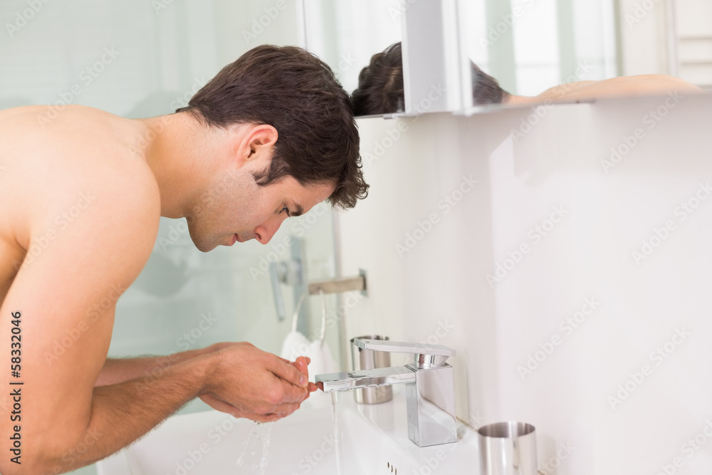 Shirtless young man washing face in the bathroom Stock Photo | Adobe Stock
