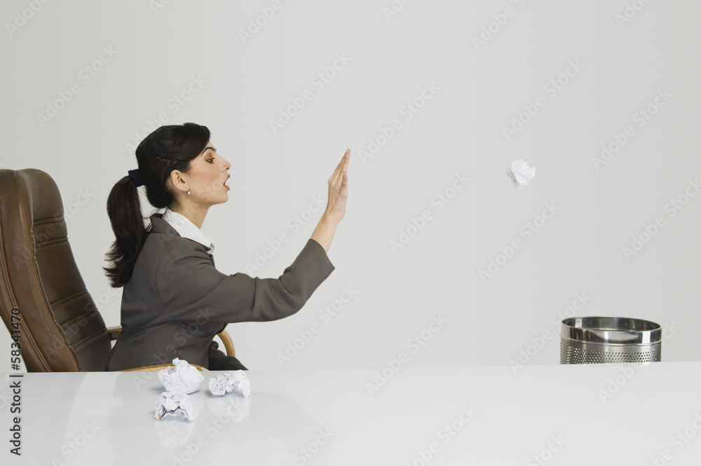 Businesswoman throwing crumpled paper into a wastepaper basket Stock ...