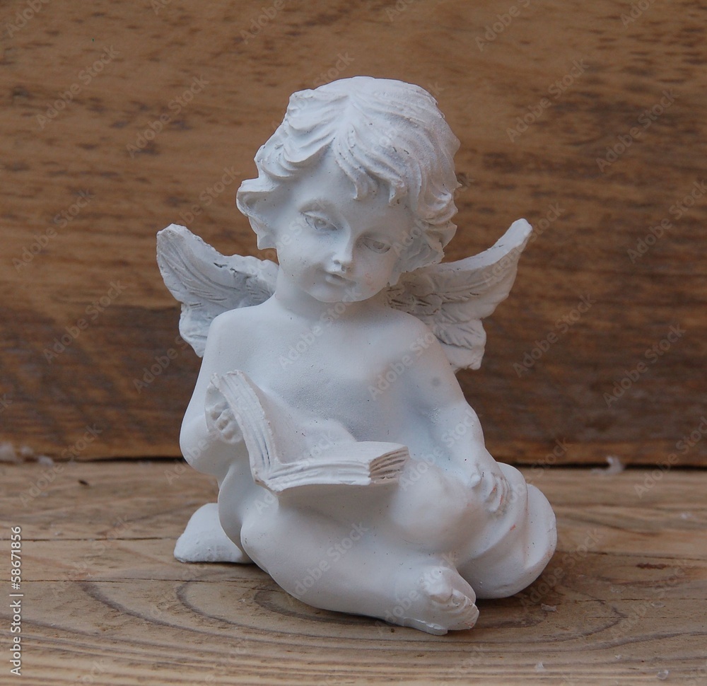 Kleiner weißer Engel mit Buch auf Holz Stock-Foto | Adobe Stock