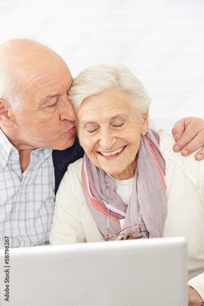 Man kissing senior woman at computer Stock Photo | Adobe Stock