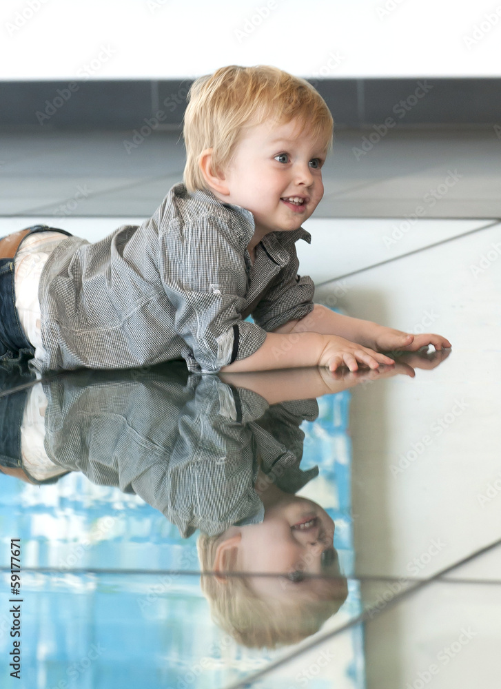 little child playing with his reflexion on the floor Stock Photo ...