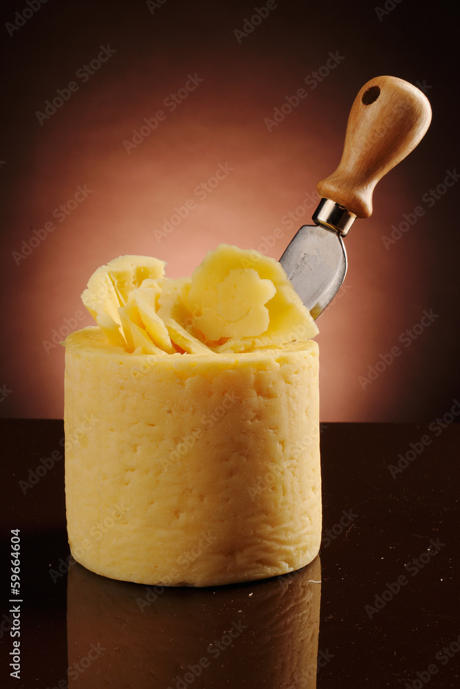 Cheese wheel with knife Stock Photo | Adobe Stock