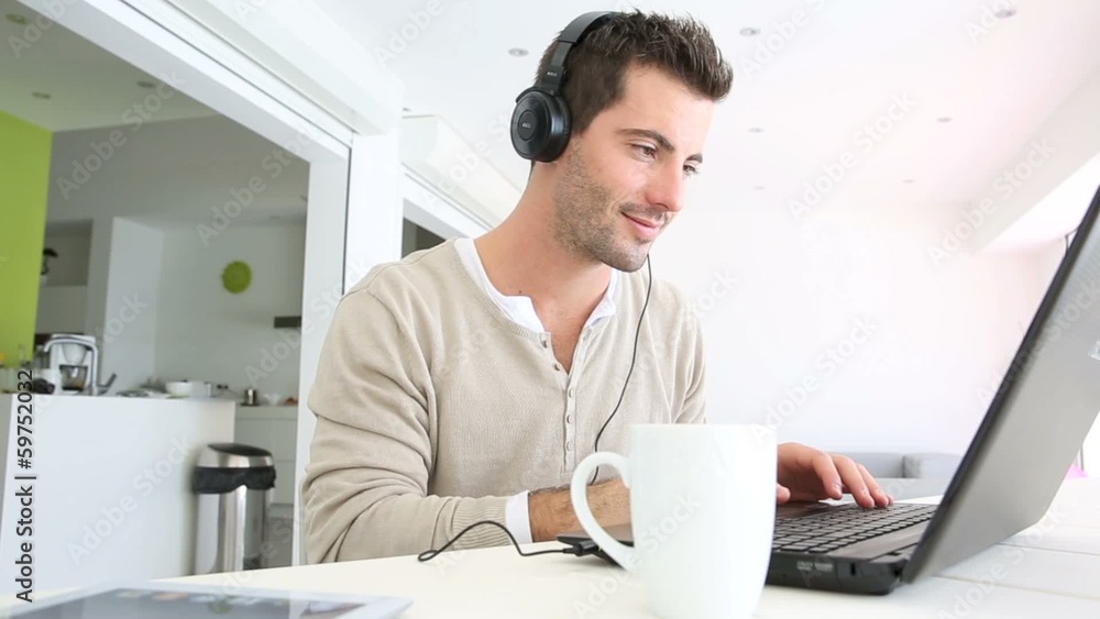 Man in font of laptop with headset on Stock Video | Adobe Stock