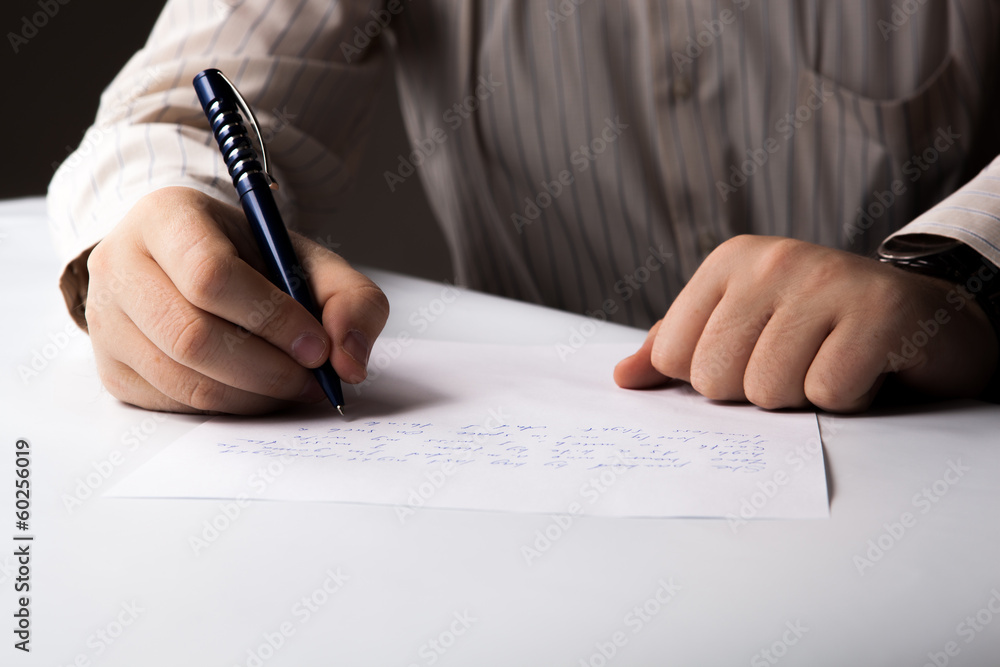 man is writting on a sheet of paper Stock Photo | Adobe Stock