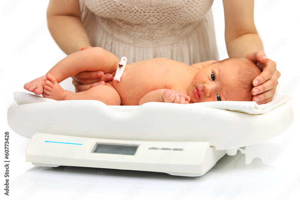 Newborn baby on a weight scale Stock Photo | Adobe Stock