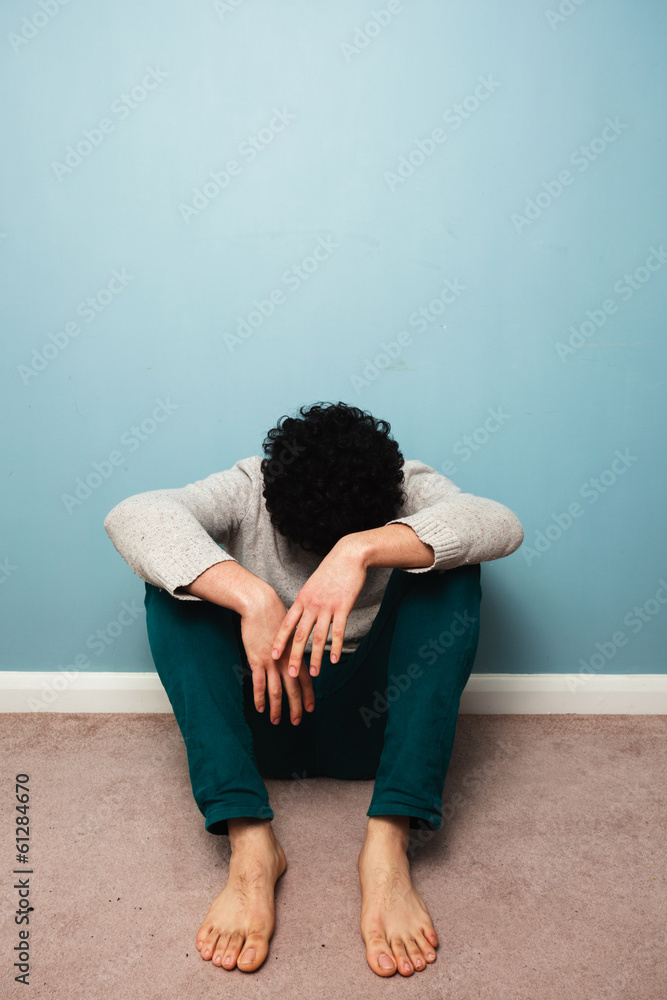 Sad man sitting on the floor Stock Photo | Adobe Stock