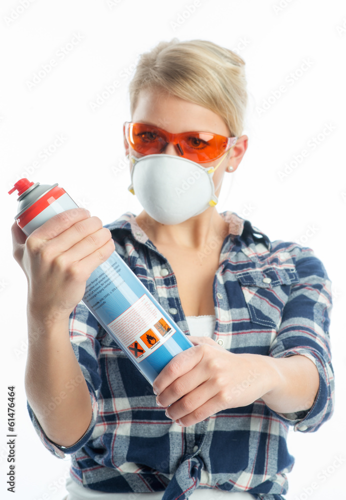 Frau mit Mundschutz hält eine Sprühdose Stock-Foto | Adobe Stock