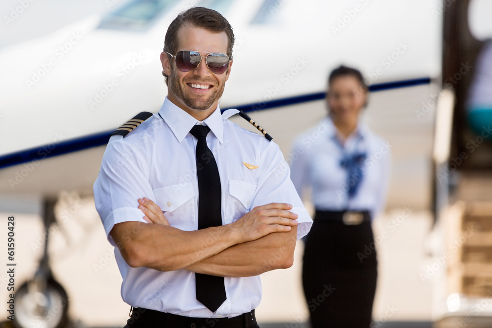 Confident Pilot Against Stewardess And Private Jet Stock Photo | Adobe ...