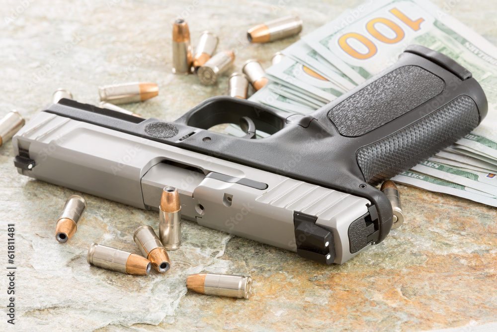 Wad of 100 dollar bills with a gun and bullets Stock Photo | Adobe Stock