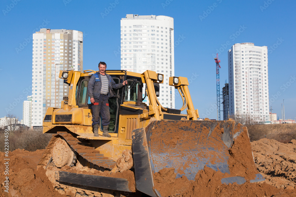 Construction worker with bulldozer during earth moving works Stock ...