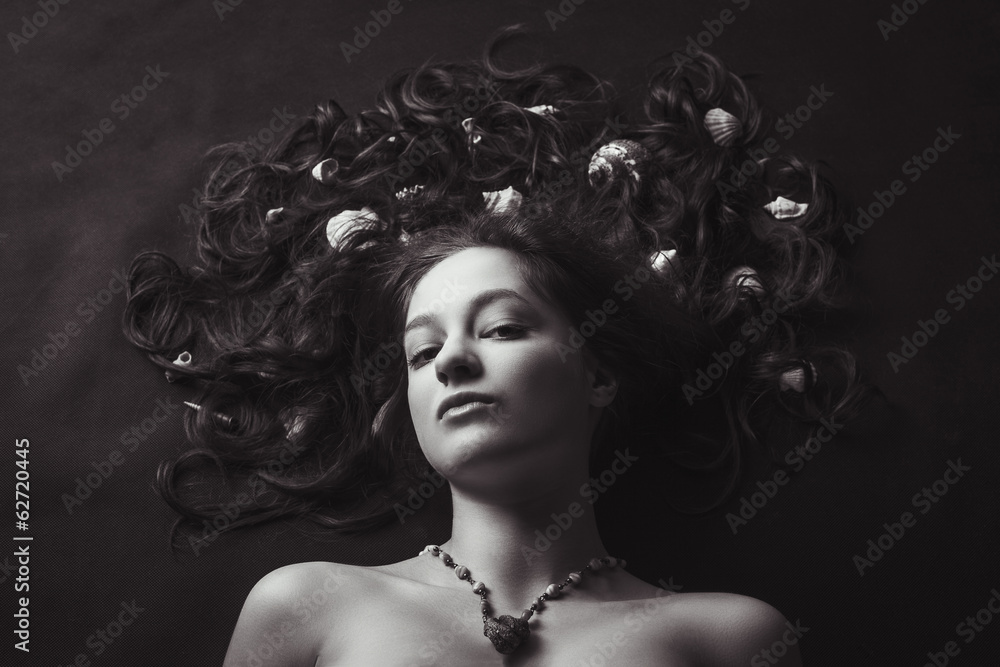 beautiful girl with wavy hair shiny and looks straight shells Stock ...