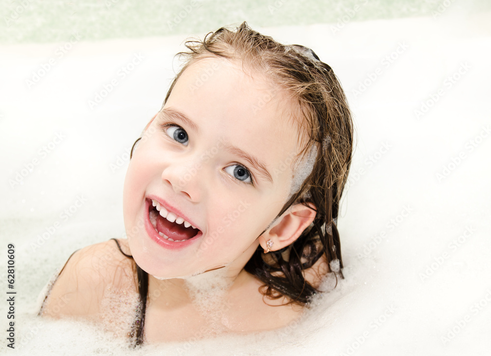 Smiling little girl washing in bath with foam Stock Photo | Adobe Stock