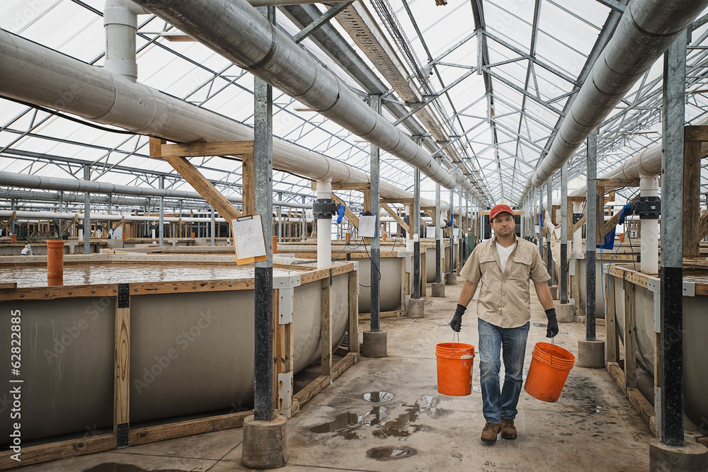 A large fish farm building interior with raised water tanks and ...