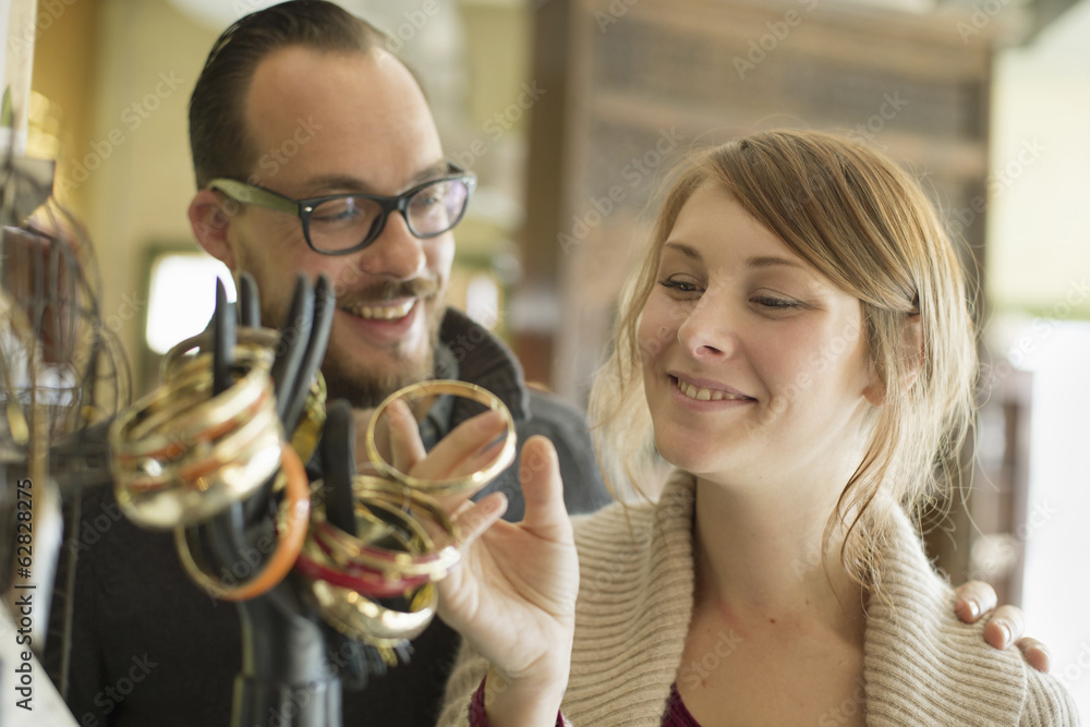 Two people, a man and woman looking at the objects displayed on a ...