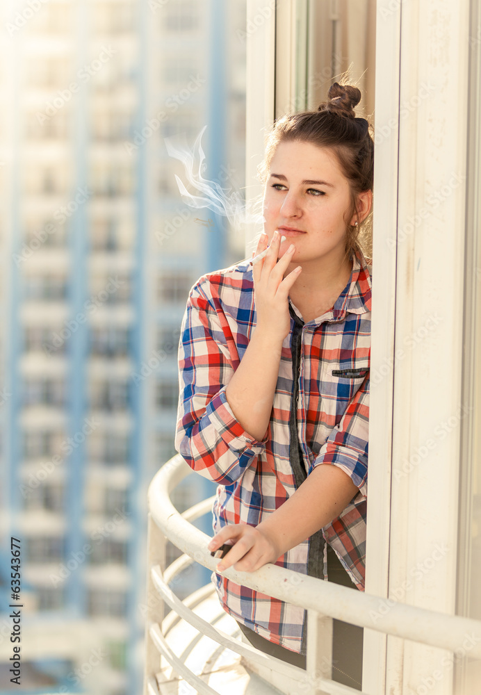 beautiful woman smoking cigarette on balcony Stock Photo | Adobe Stock