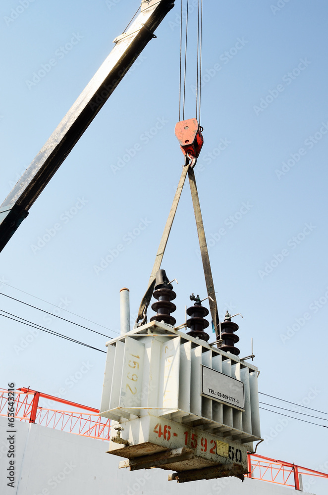 Crane hook lifts up distribution transformer Stock Photo | Adobe Stock